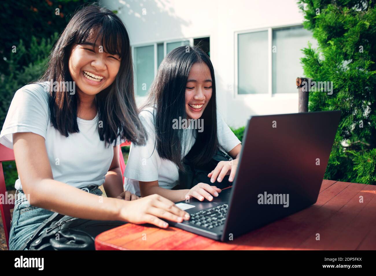 two asian teenager typing on computer labtop happiness emotion Stock ...