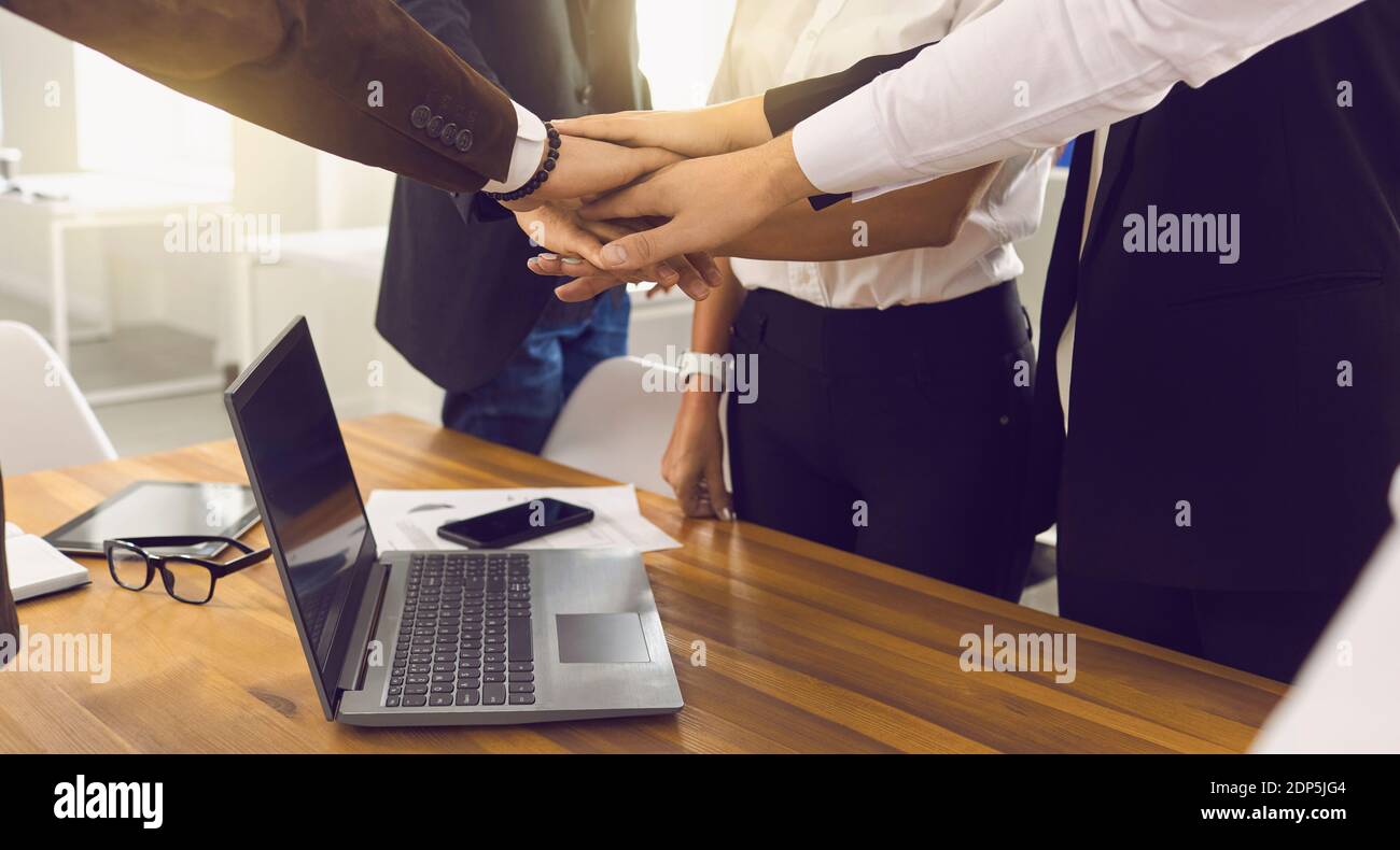Business partners joining hands over office desk, making agreement and ...