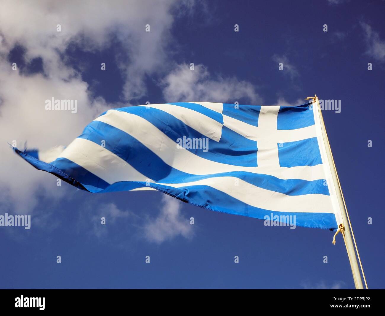 Greek flag fluttering in the wind on a bright day with a deep sky ...