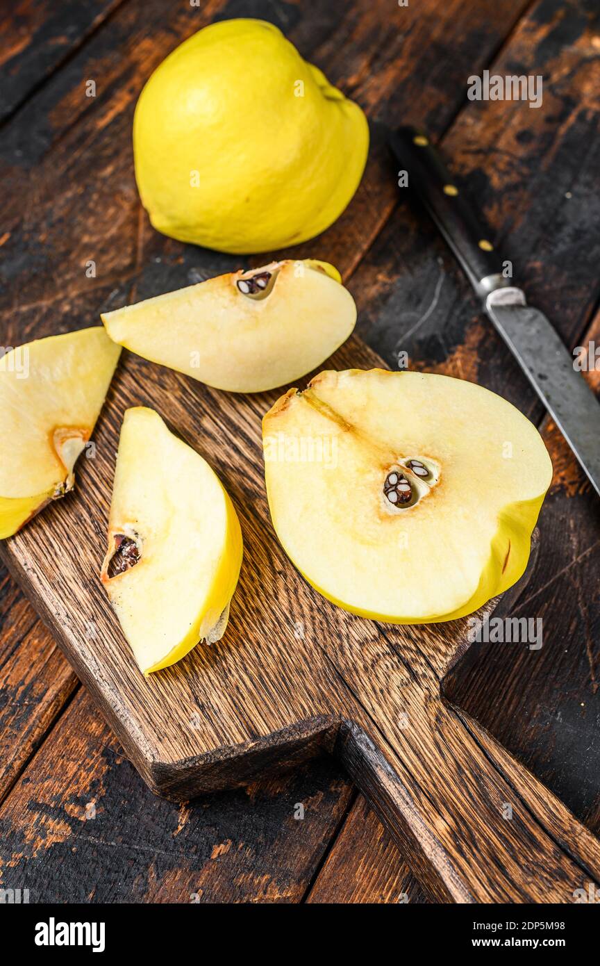 Fresh gold quince fruits on a cutting board. Dark wooden background ...