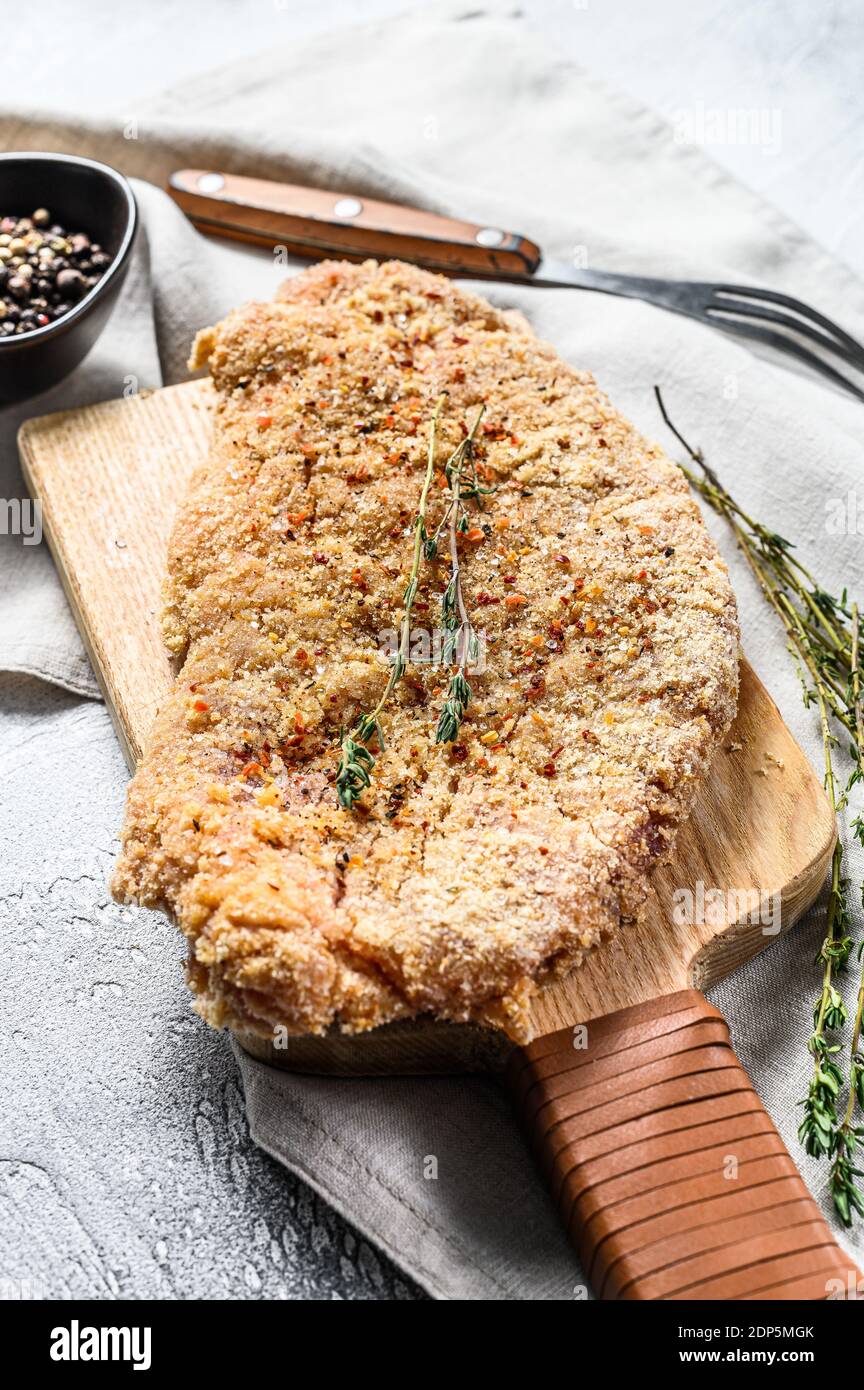 Homemade raw breaded German Weiner Schnitzel. Gray background. Top view ...