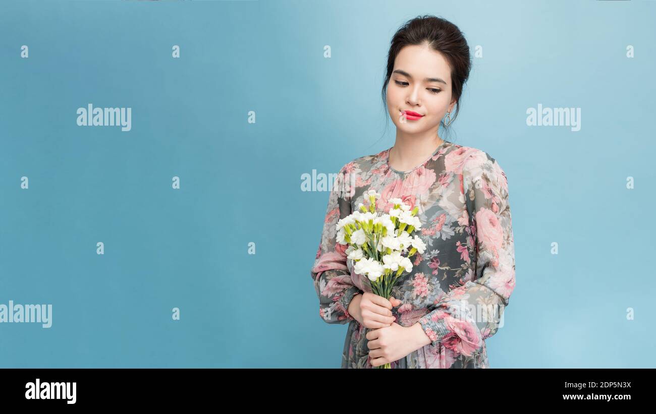 Headshot of pretty young woman with tender smile, healthy skin, carries ...