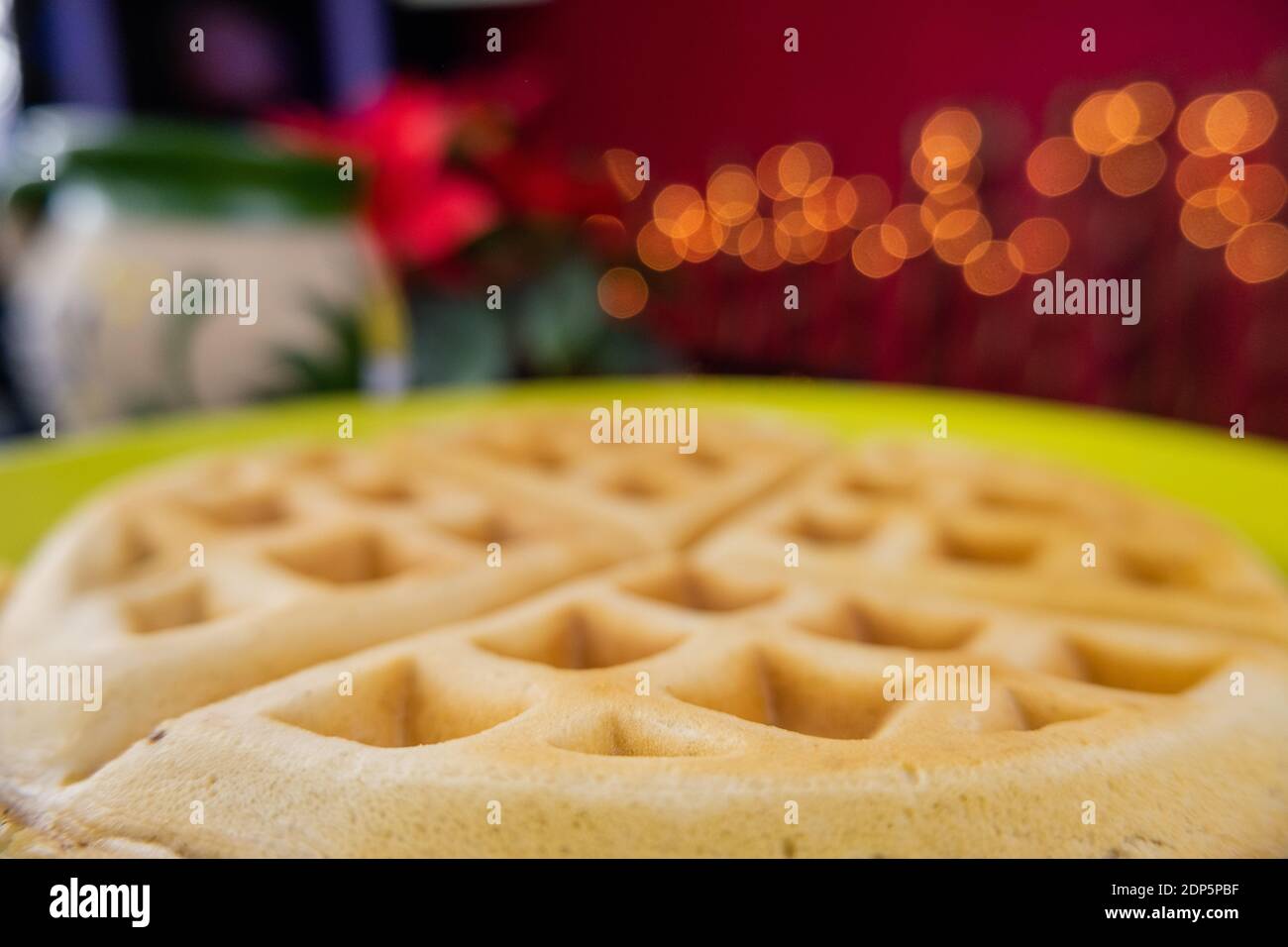 Round waffle on a yellow plate with Mexican clay cup as background ...