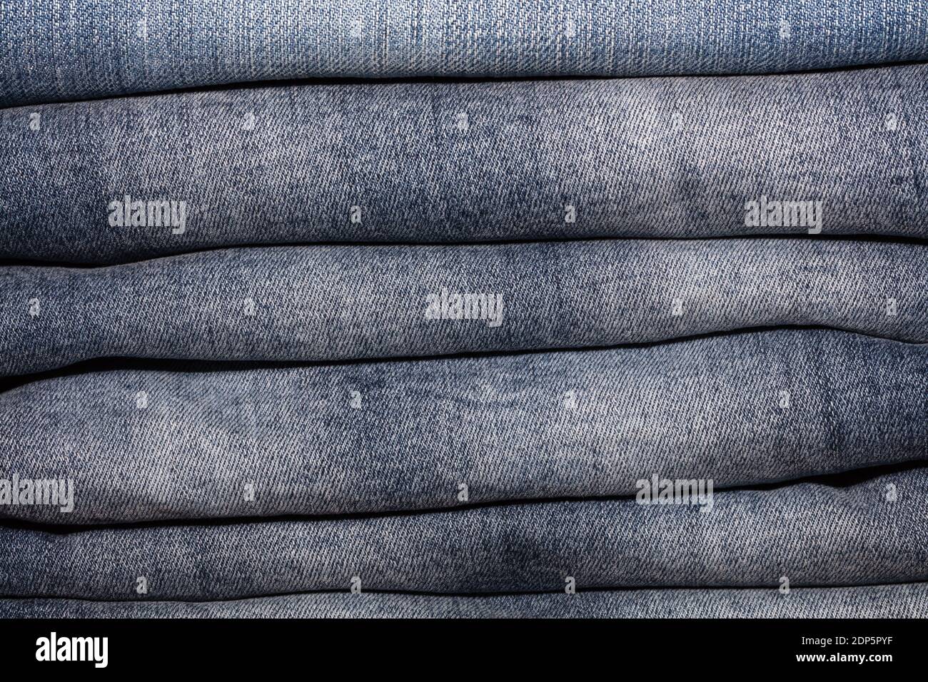 Closeup shot of stack of folded white jeans in fashion store. Shopping ...