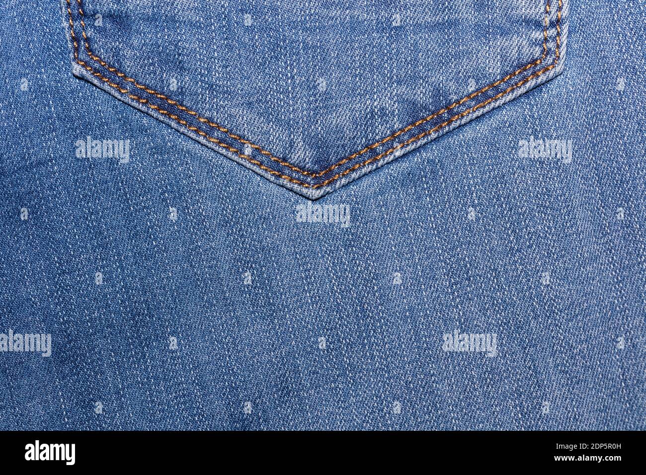 Pointy bottom part of a pocket of blue denim jeans. Close up shot. Top ...