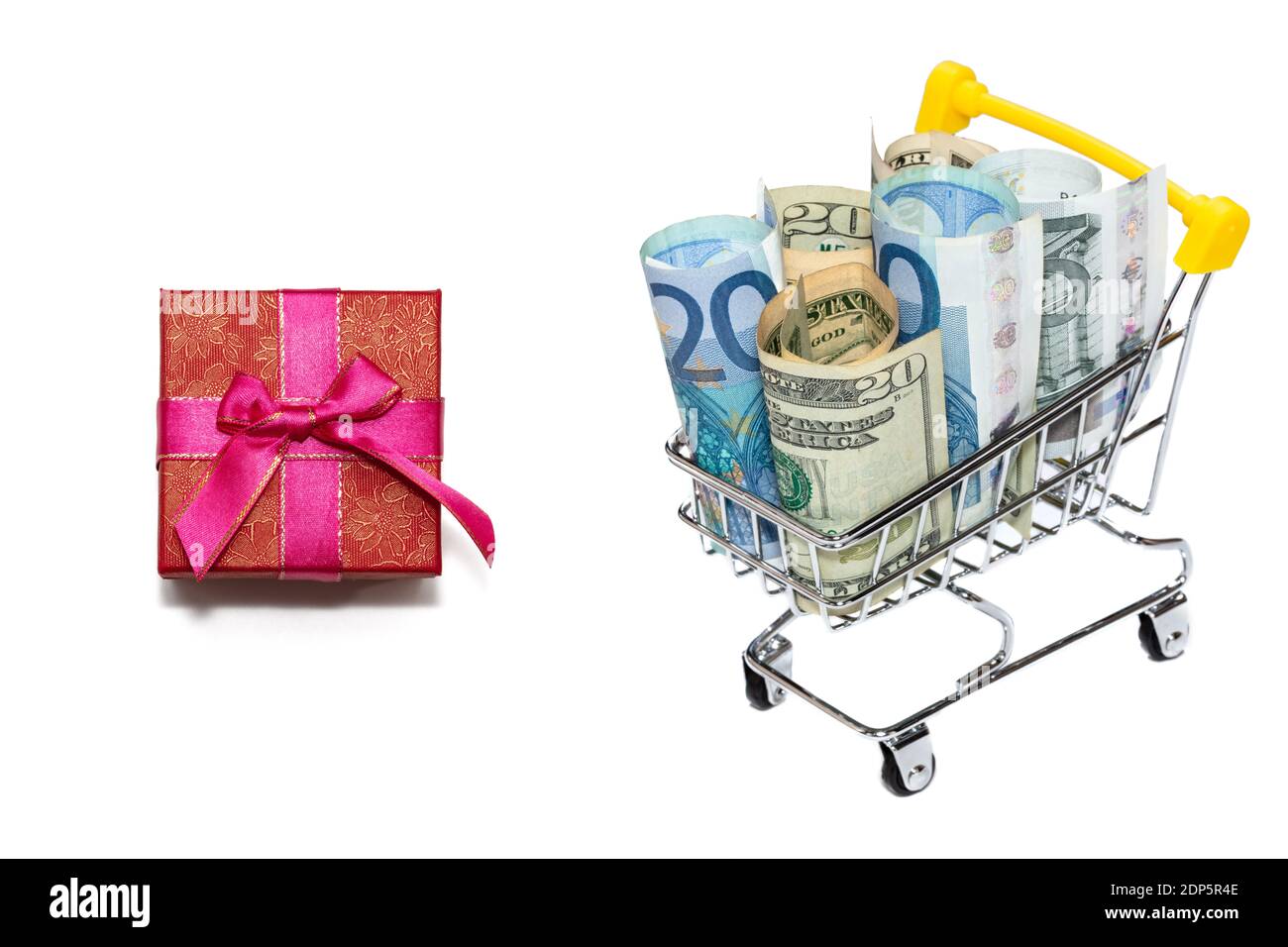 Shot of a red gift box next to a shopping cart full of euro and dollar ...