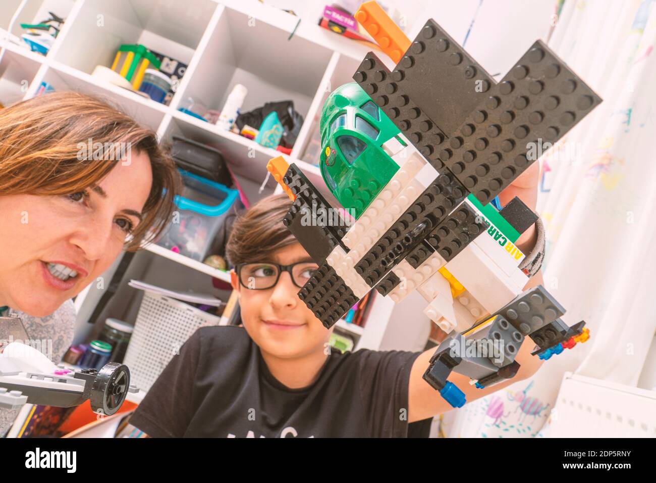 Female teacher is teaching her student by playing with toys ...