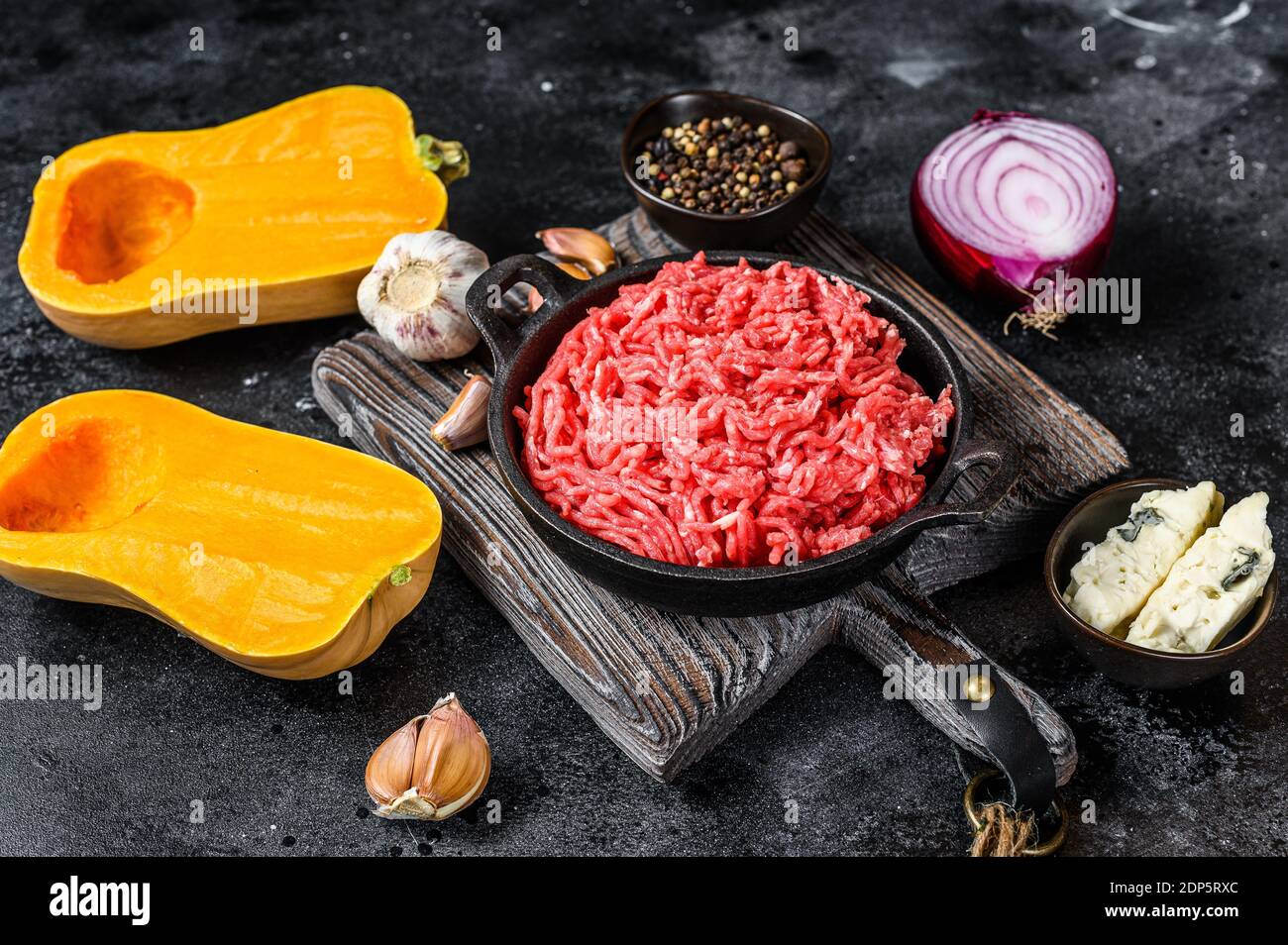 Raw mince meat, pumpkin with garlic and onion. Black background. Top ...