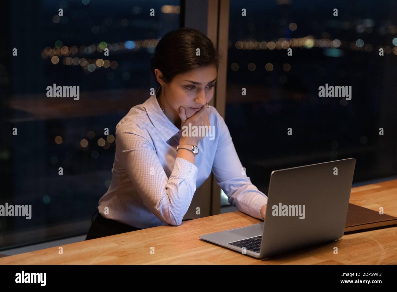 Pensive Indian female employee work in office late Stock Photo - Alamy
