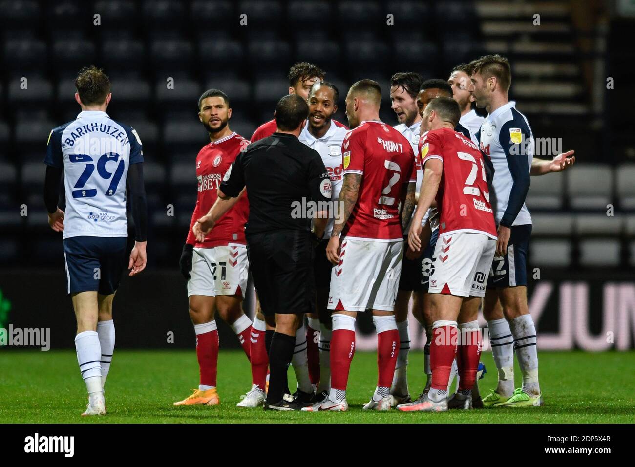 Players from both teams surround the referee after he makes a decision ...