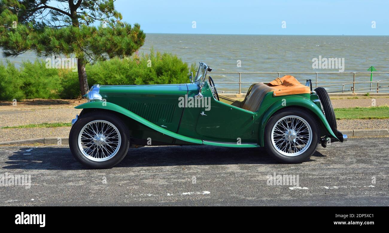 Classic Green MG parked on coastal road with the ocean in the ...