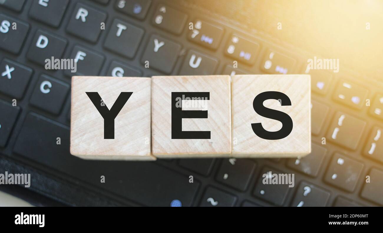 The word Yes on wooden blocks on computer keyboard. Business ...