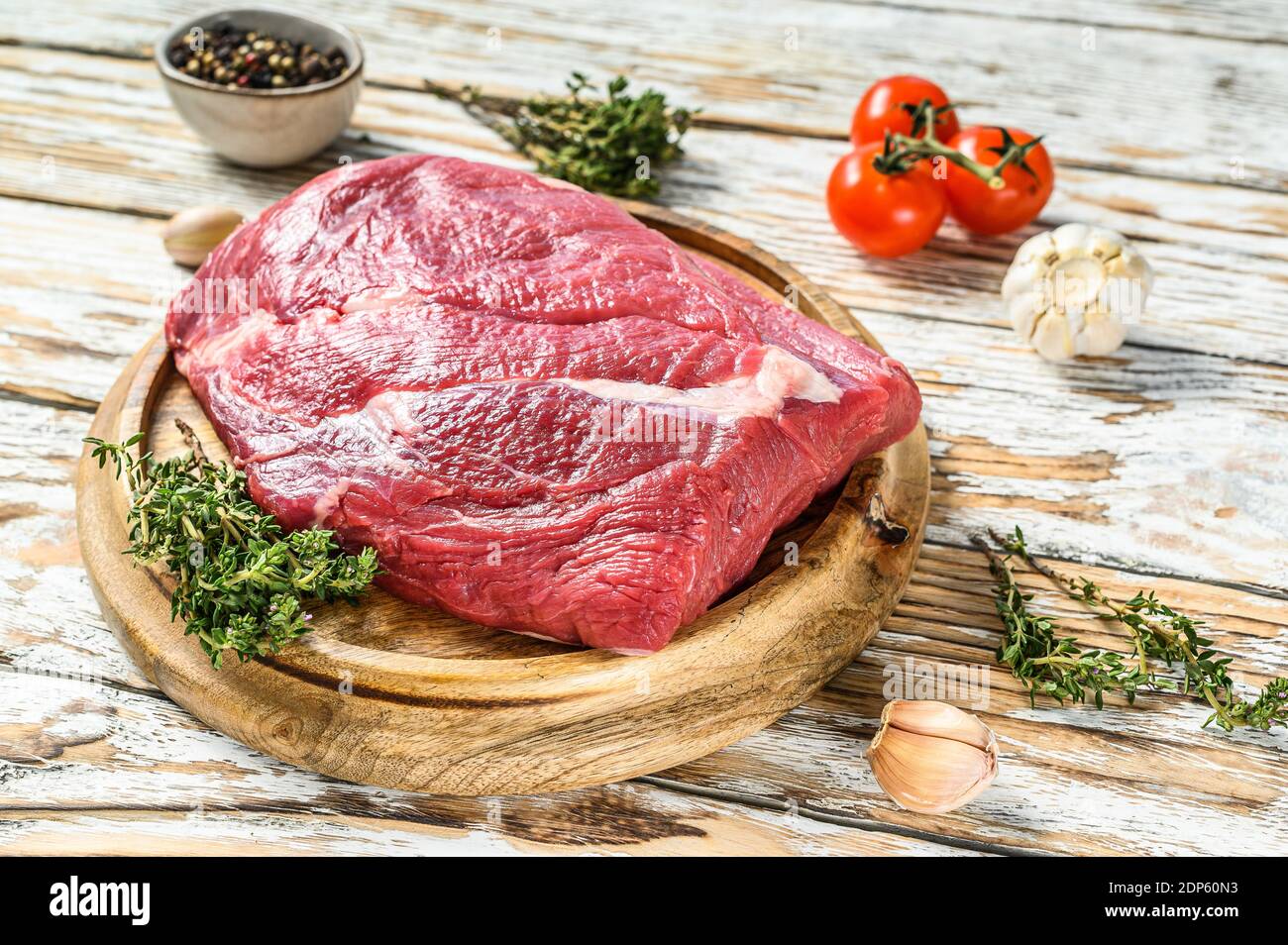 Raw Round beef cut on a wooden board. White background. Top view Stock ...