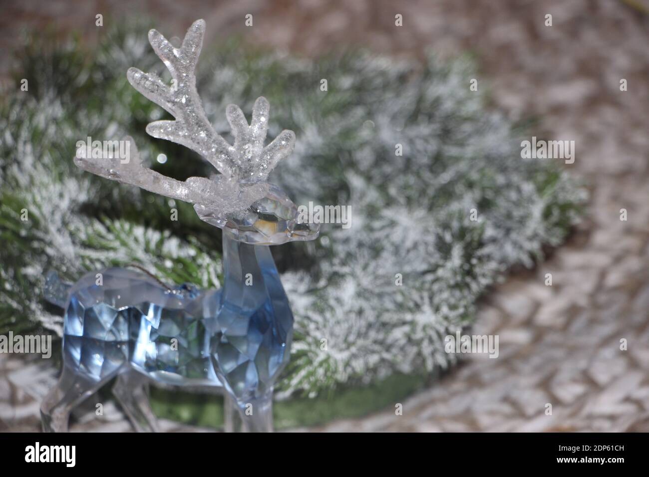 Crystal deer statuette in front of snowy fir. Christmas background ...