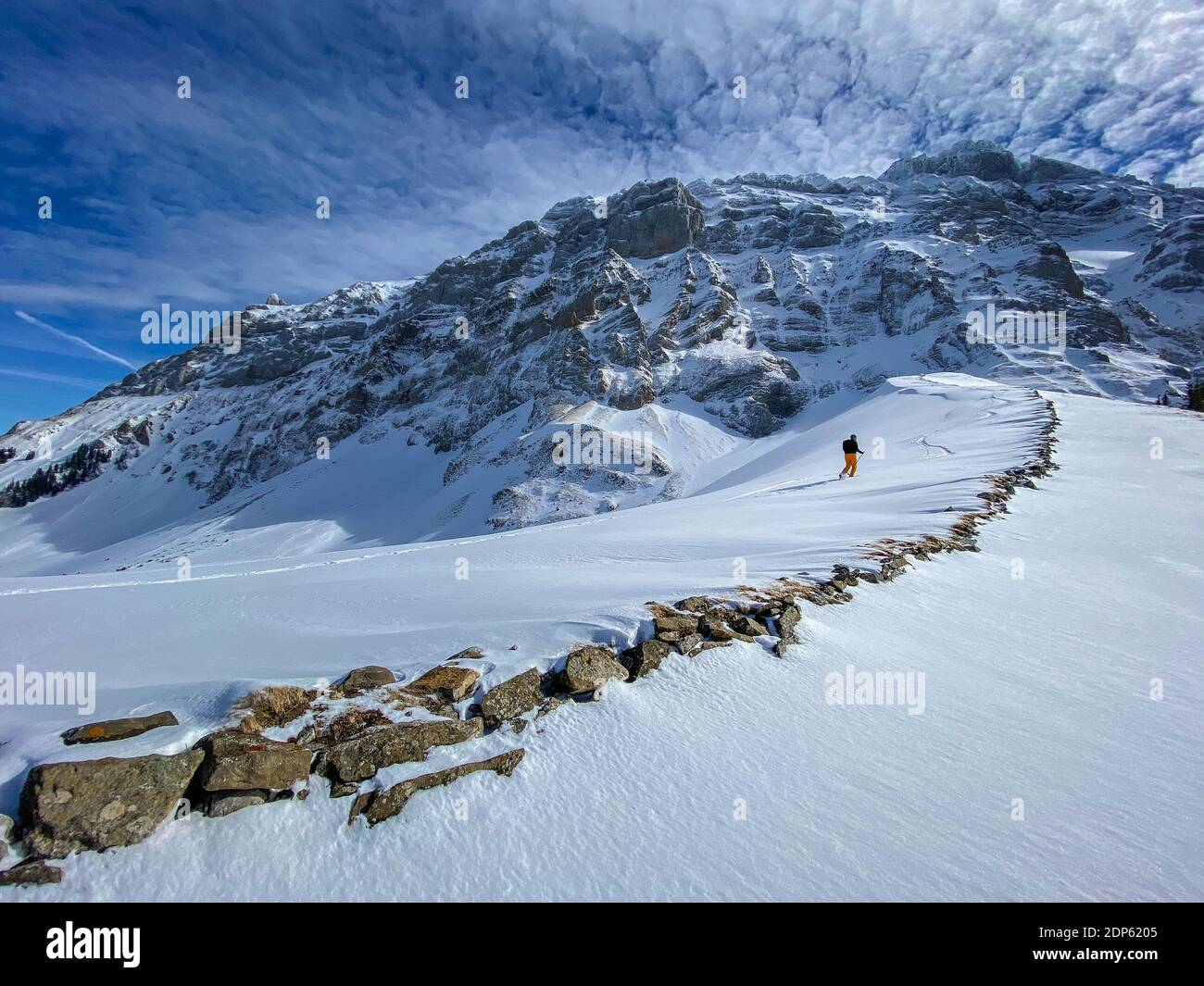 Winter sports - young man walking with snowshoes uphill in high ...