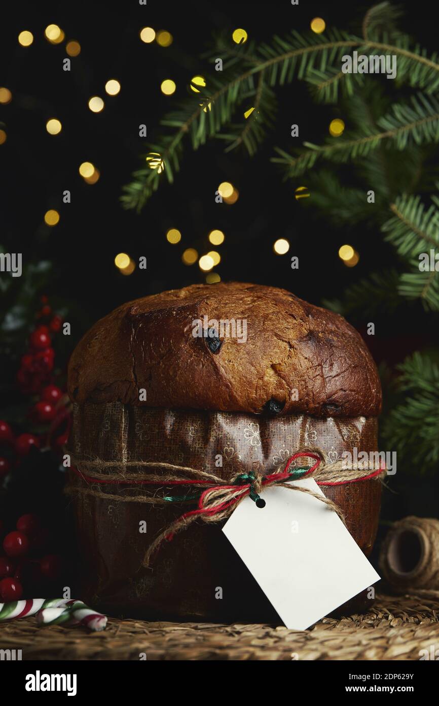A Christmas panettone with raisins and candied fruit with a small blank ...