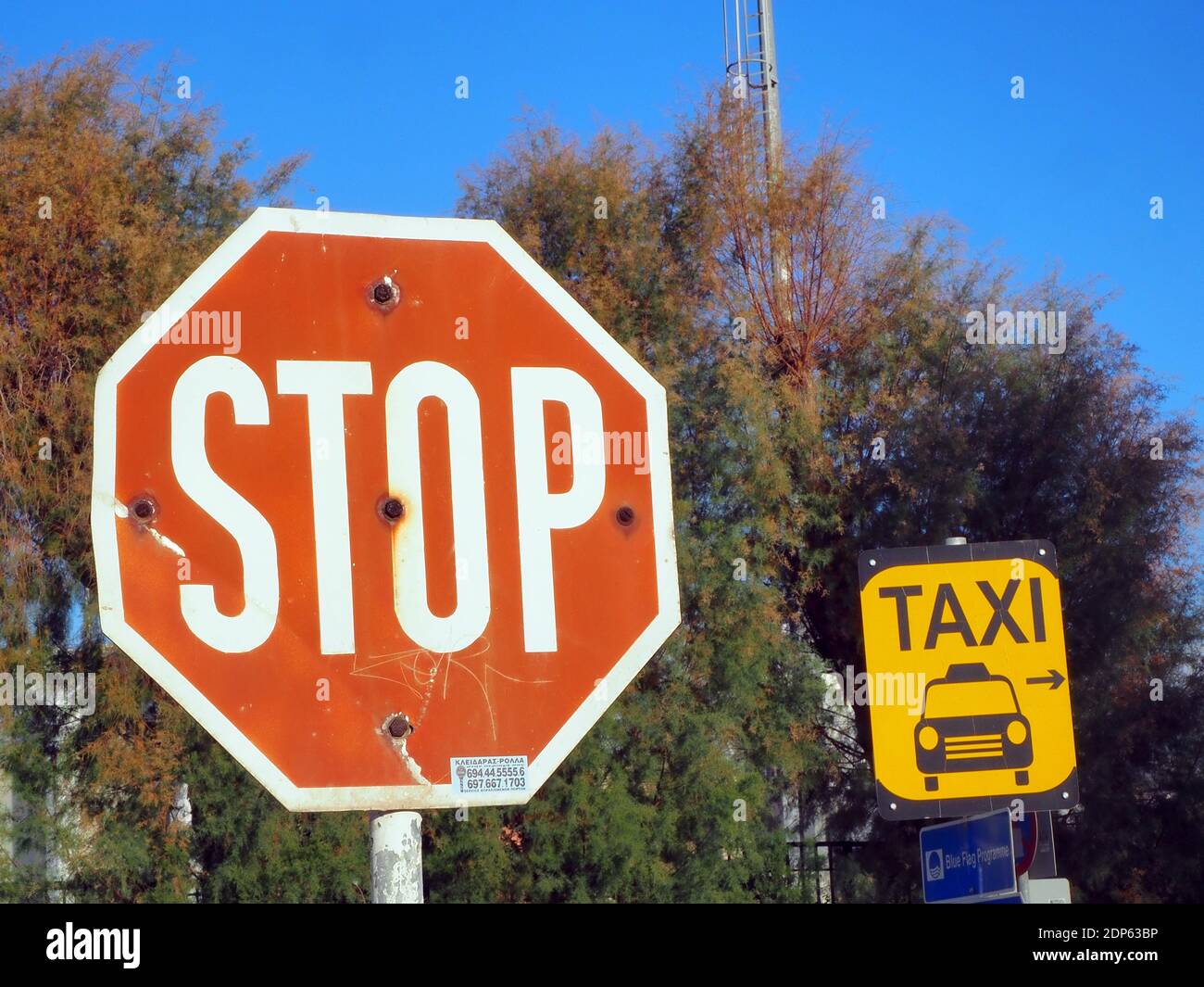 Various signs on the street in red, yellow, black, white and blue at a ...
