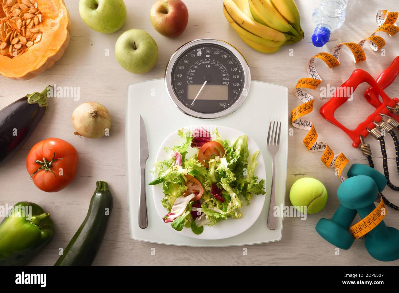 Weight control concept with scale with salad plate and cutlery on top ...