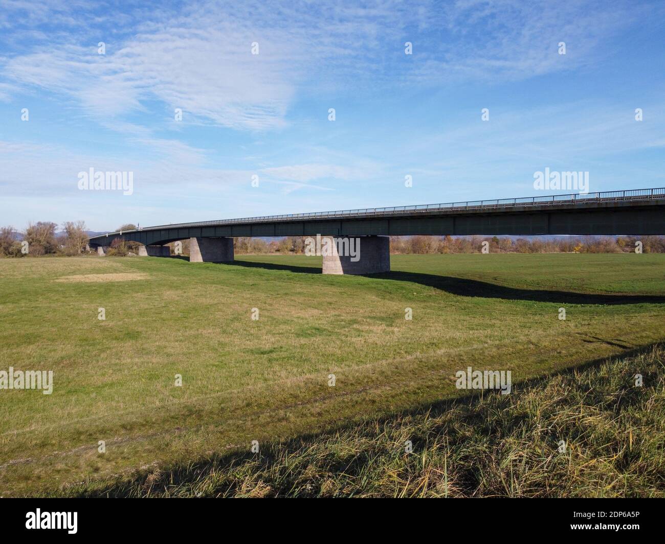 A beautiful shot of a long stone bridge of railway crossing the grass ...