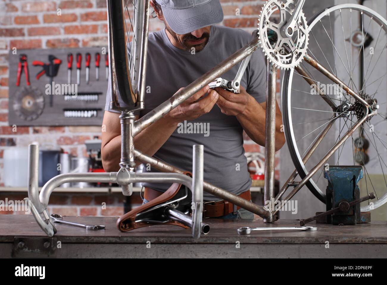 man repair the vintage bicycle in garage workshop on the workbench with ...