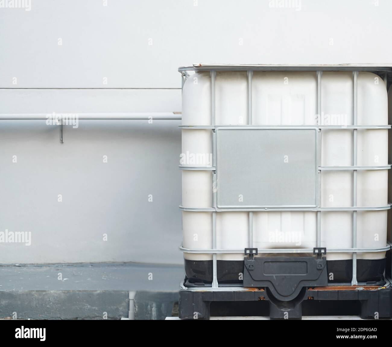 A liquid storage tank beside the wall of the building Stock Photo - Alamy