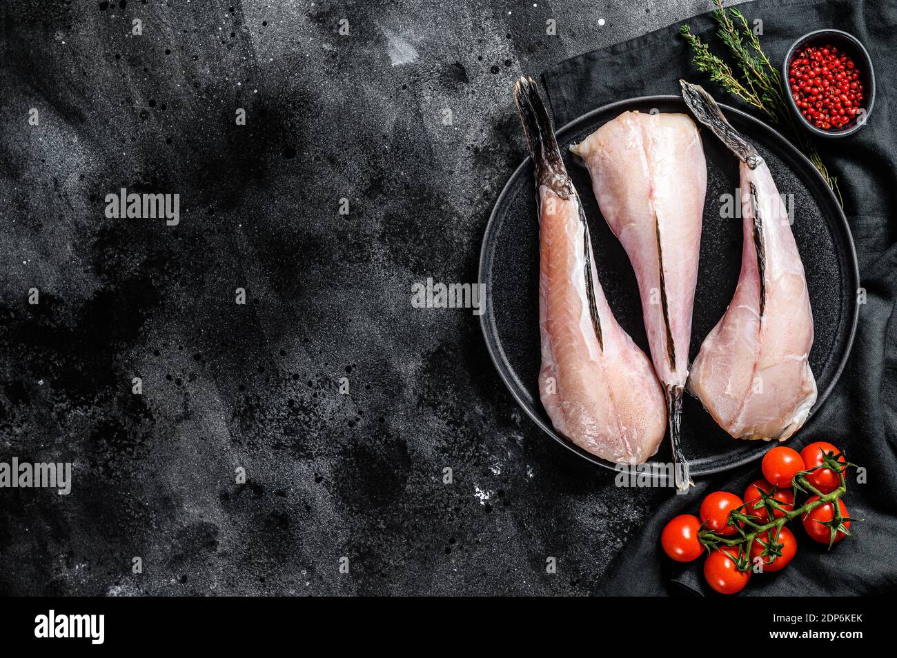 Separate raw fish monkfish. Black background. Top view. Copy space ...
