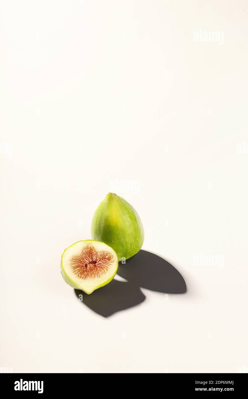 A whole fig and a half fig isolated on white background with lighting ...