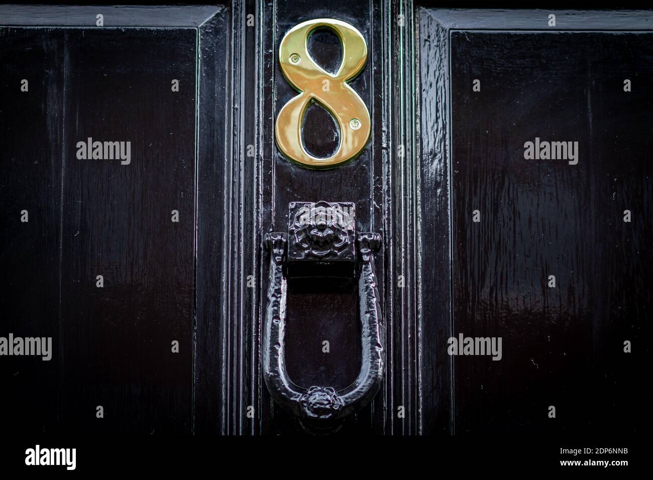 Large and bold 8 on a black wooden front door Stock Photo - Alamy