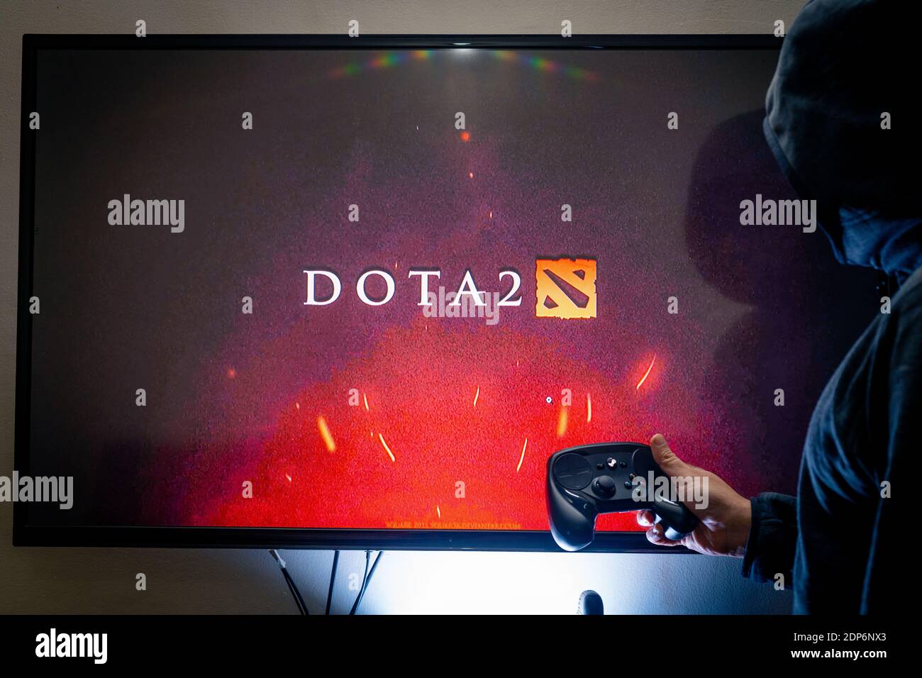 Man holding a steam controller and playing popular video game DOTA 2 on ...