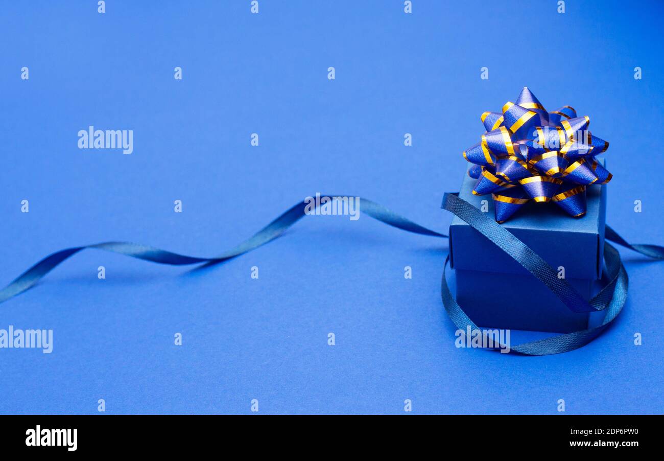 classic blue surprise gift box with blue ribbon, background with copy ...