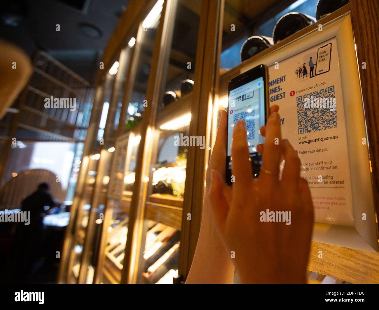 Sydney, Australia. 19th Dec, 2020. A woman scans QR code before ...