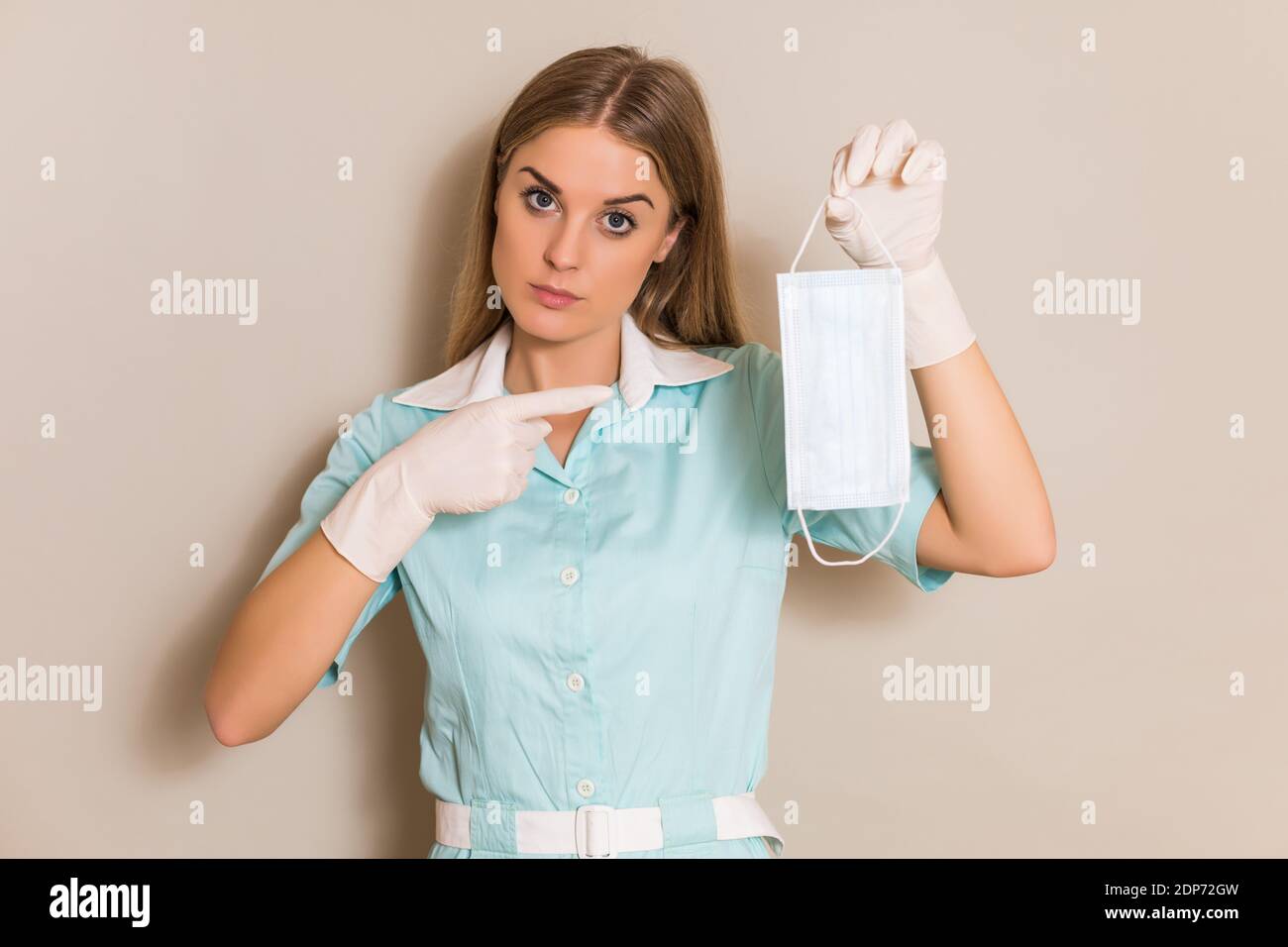 Portrait of medical nurse pointing at protective mask Stock Photo - Alamy
