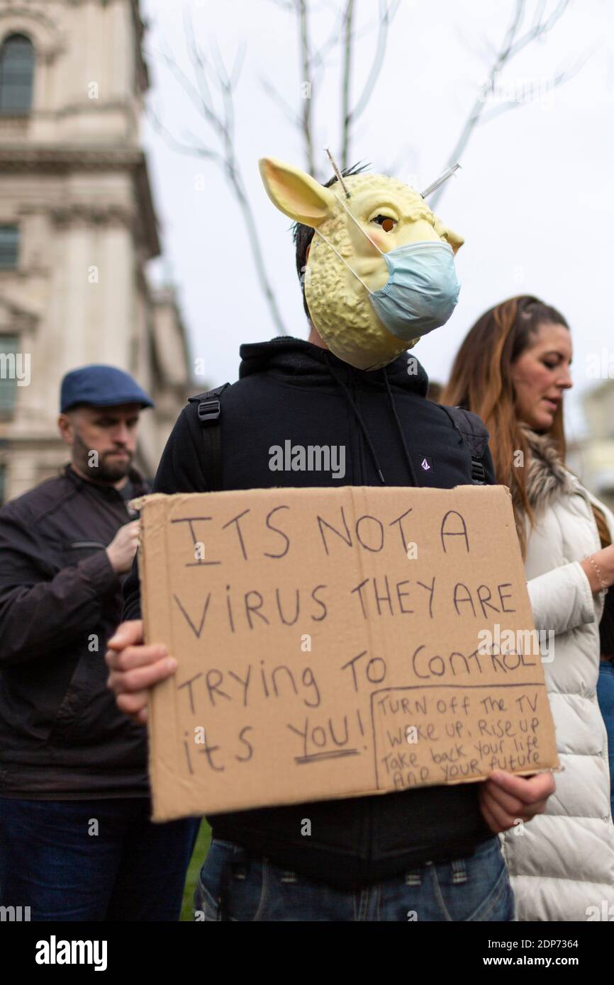Protester wearing sheep mask and holding placard during COVID-19 anti ...