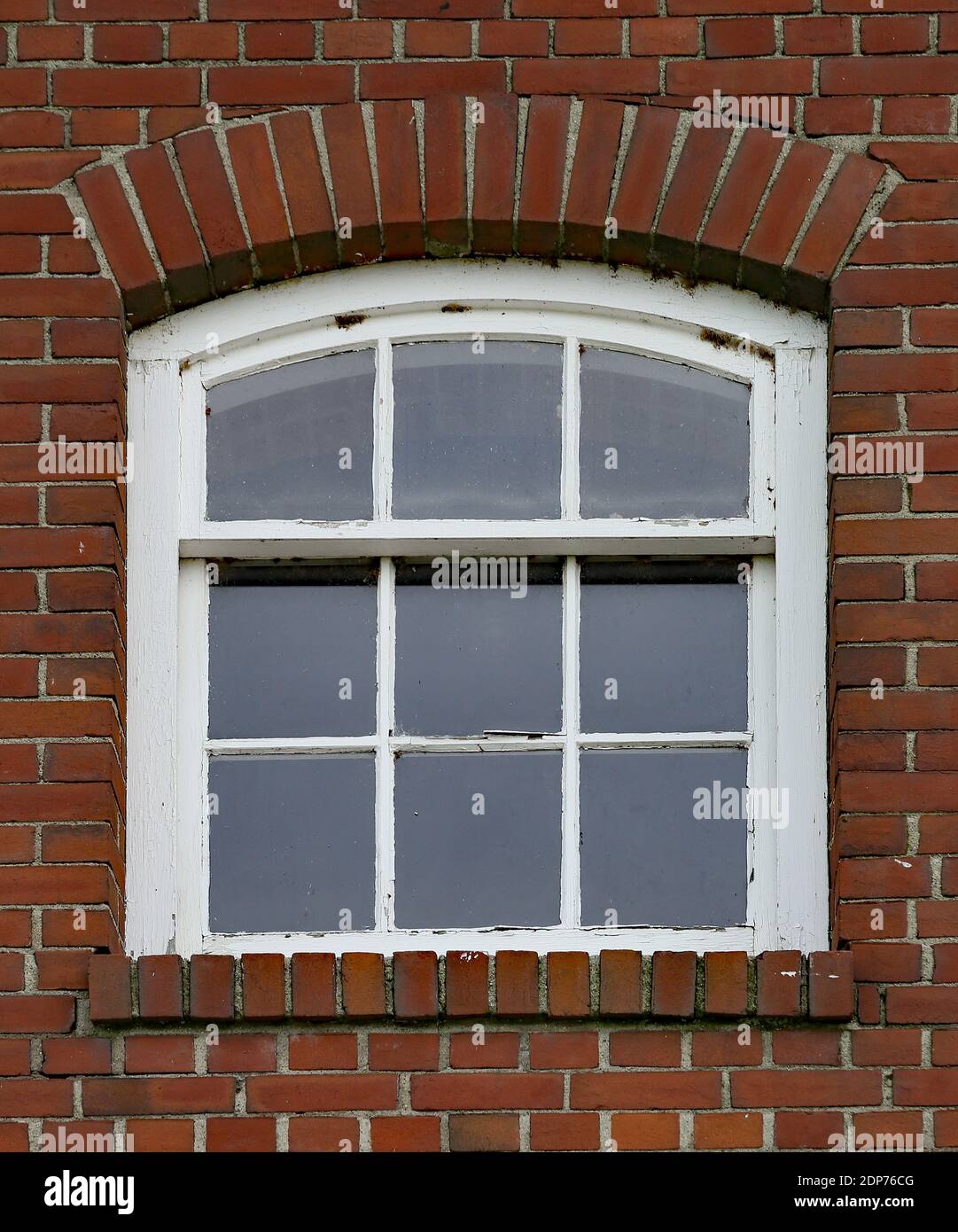 Nine pain glass window with white trim set in a red brick wall Stock ...