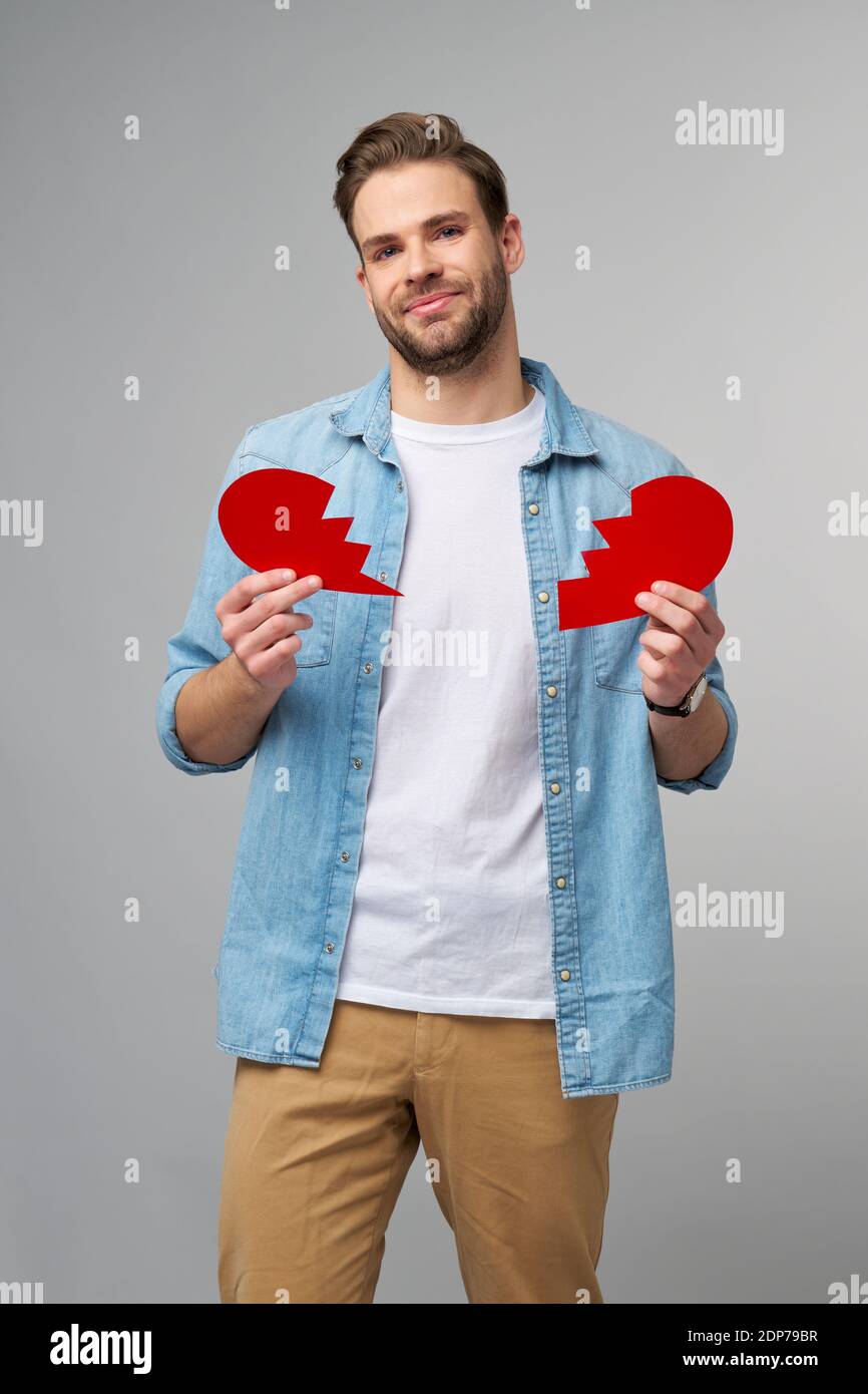 handsome young man holding broken paper red valentine heart standing ...
