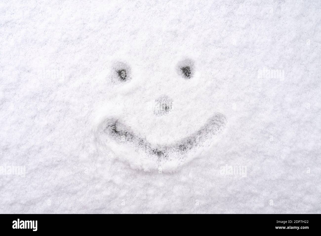 a face with a smile drawn on white snow in winter with a close-up Stock ...