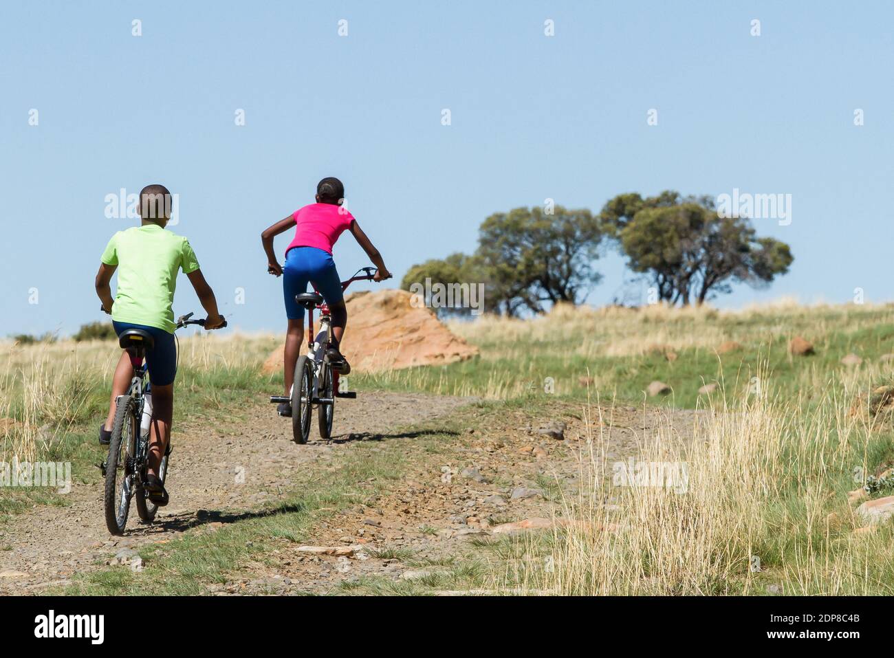 Two African boys riding on bikes on a stony ground Stock Photo - Alamy