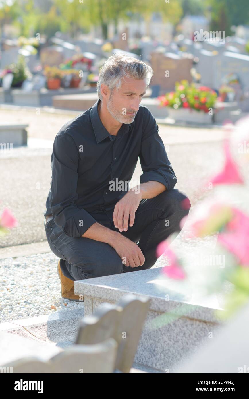 portrait of man mourning at a grave Stock Photo - Alamy