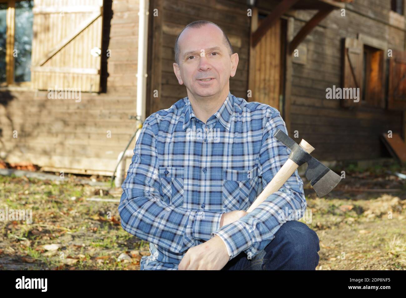 man holding an ax posing Stock Photo - Alamy