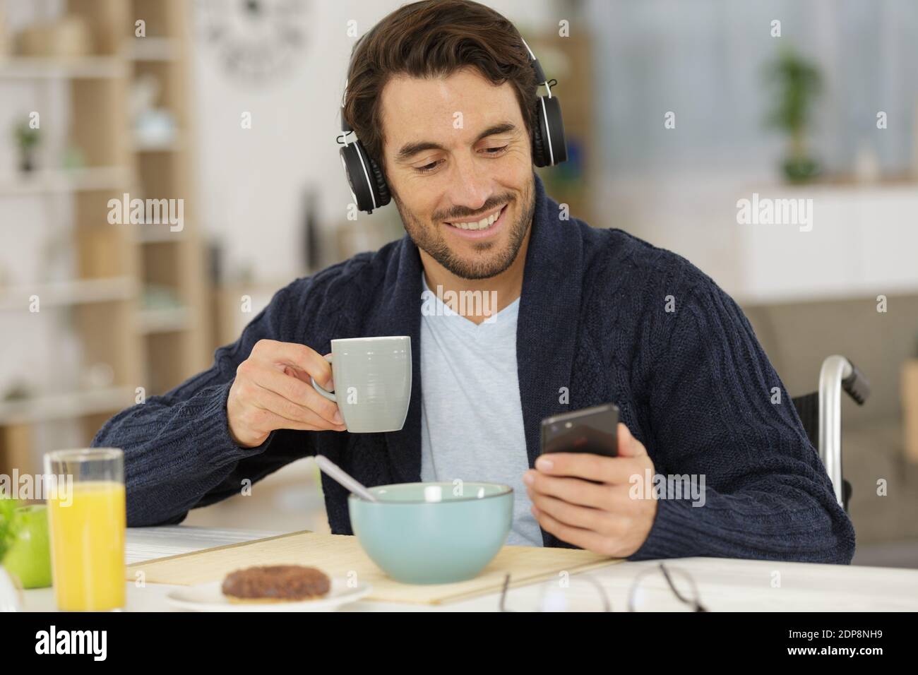 young disabled man listening music while having breakfast Stock Photo ...