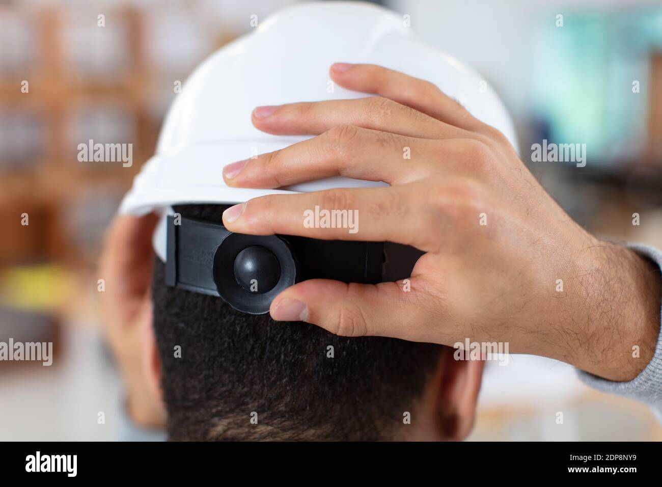young builder adjusting helmet by hands Stock Photo - Alamy