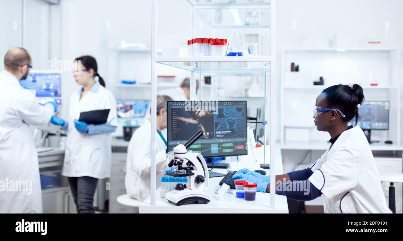 African scientist sitting at her workplace in modern facility for ...