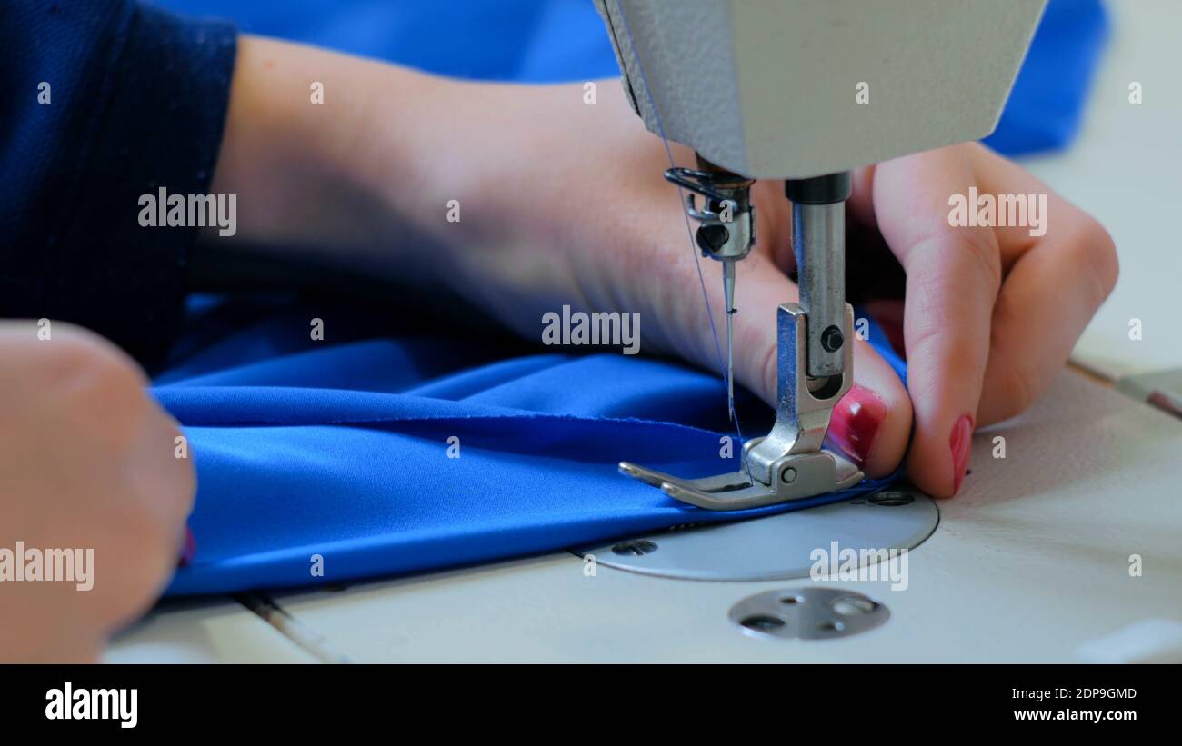 Professional tailor, fashion designer sewing clothes with sewing ...