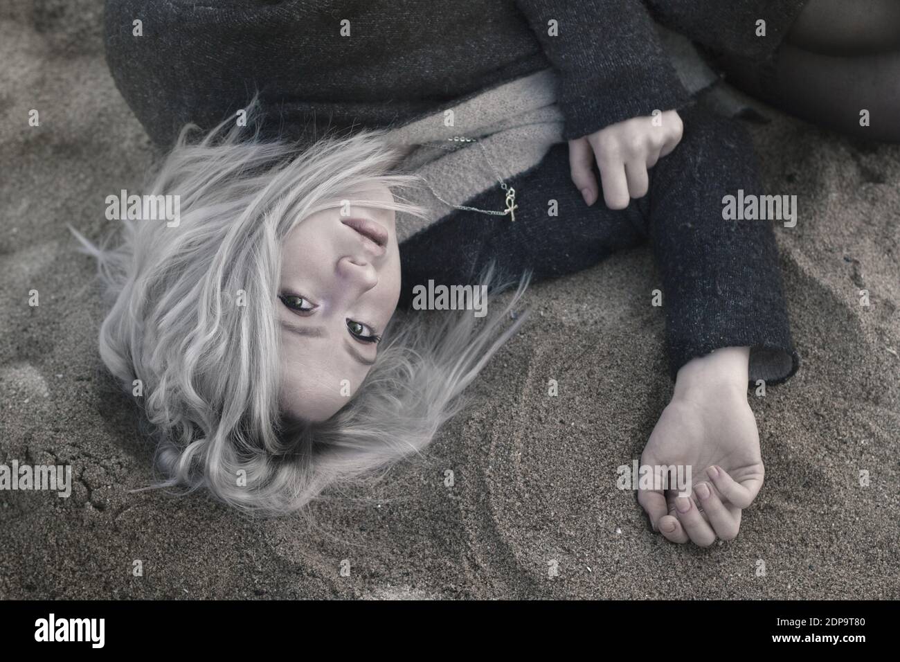 High Angle Portrait Of Sad Woman Lying On Sand At Beach Stock Photo - Alamy