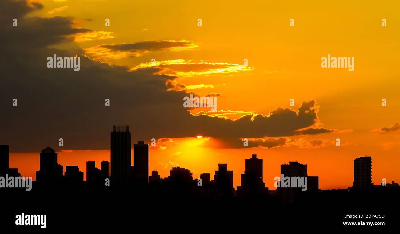A silhouette of a cityscape on background of beautiful cloudscape in ...