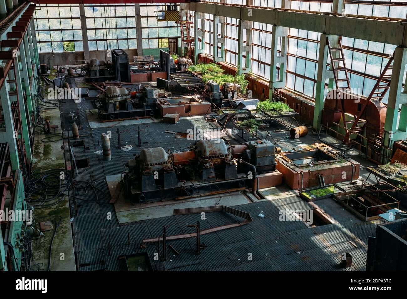 Old abandoned overgrown factory with rusty remains of industrial ...