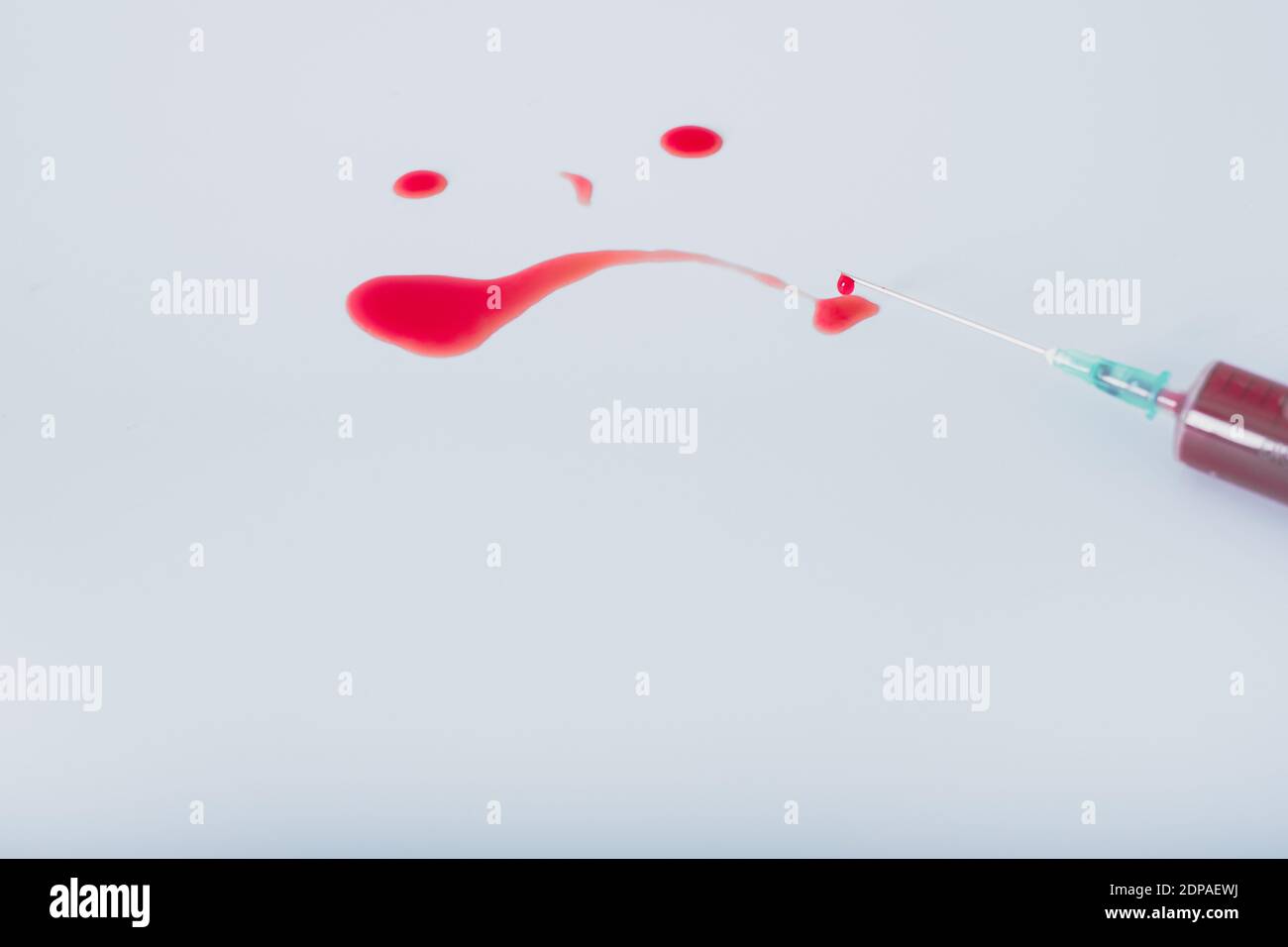 drop of blood from a syringe on a blue background. sad emoji with blood ...
