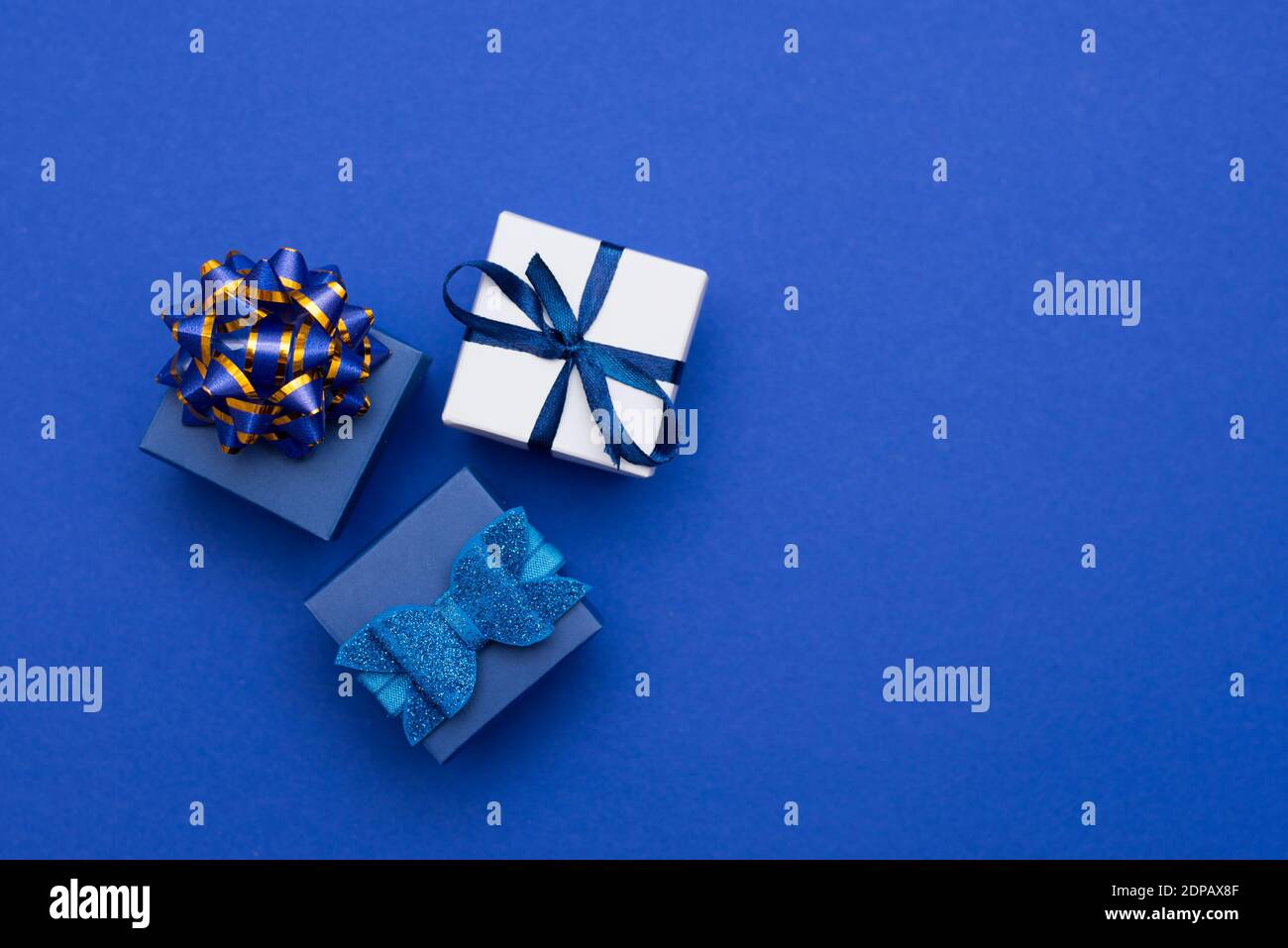 blue gift boxes with gold bow - top view - on classic blue background ...