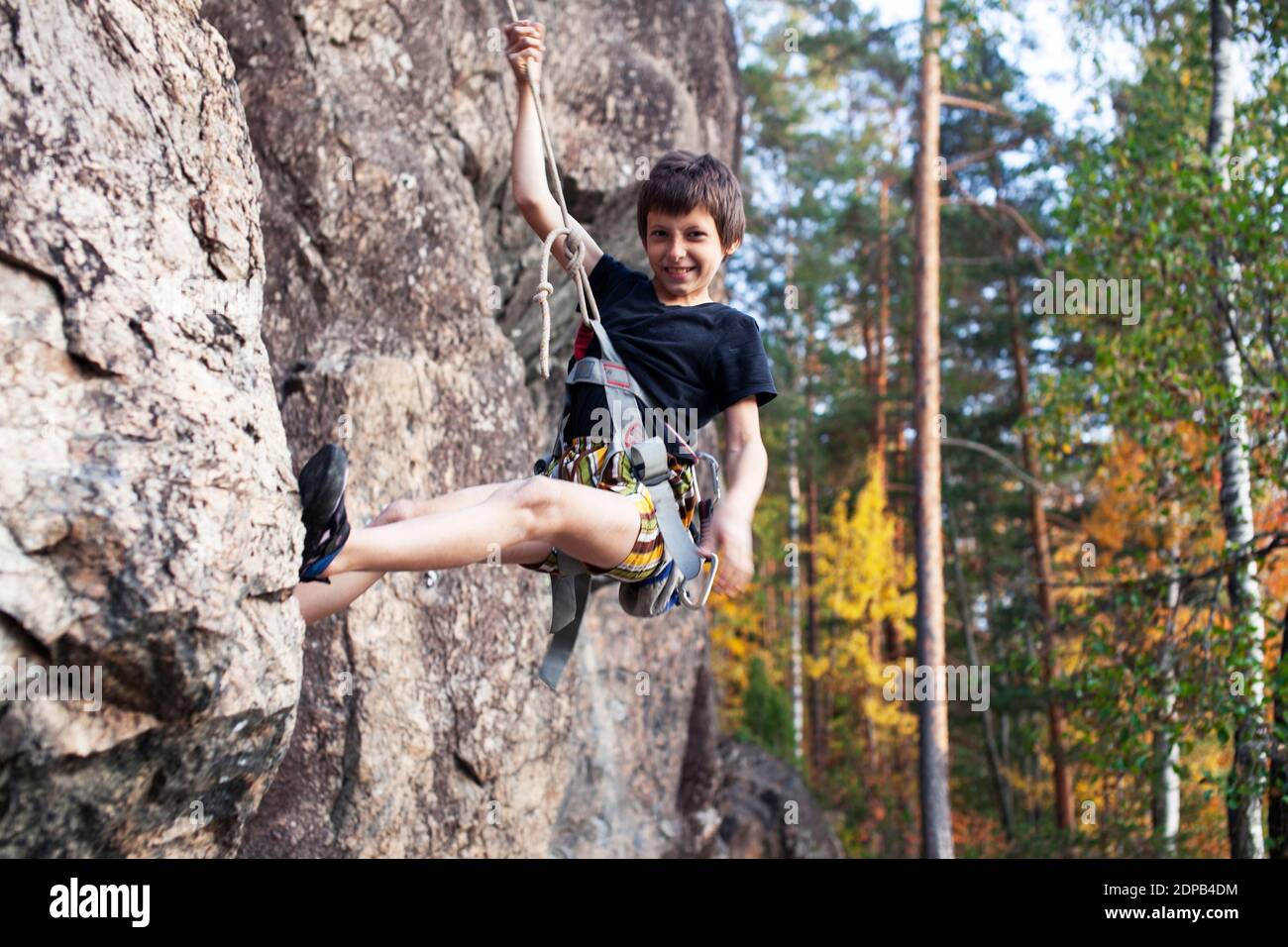 cute teen kid climbing on rock with insurance, lifestyle sport people ...