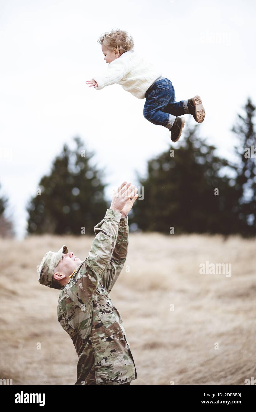 A soldier father father tossing up his little son Stock Photo - Alamy